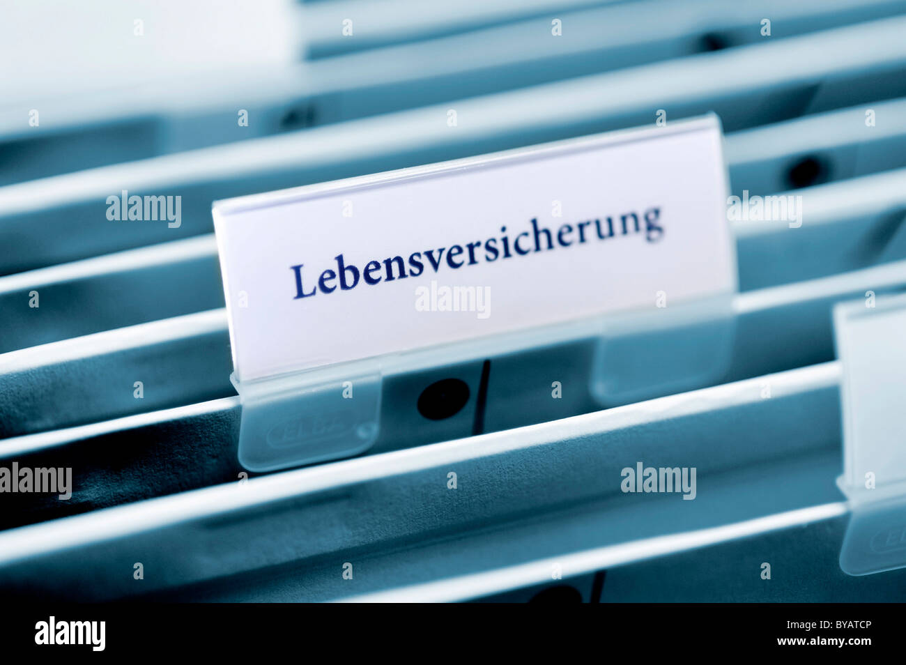 Rider on a hanging folder labeled Lebensversicherung or life insurance ...