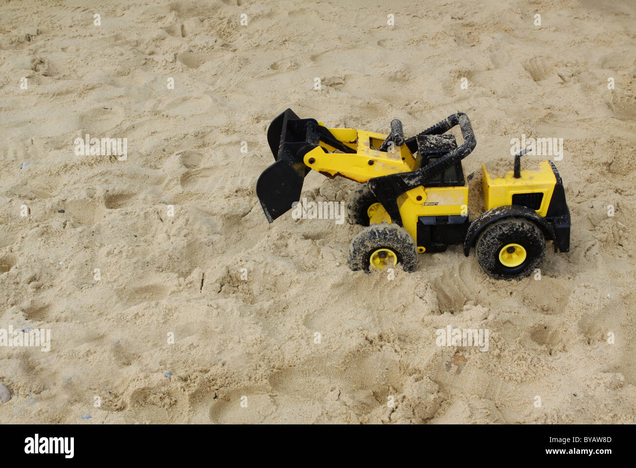 Child's toy big yellow machine working in sand environment Stock Photo ...