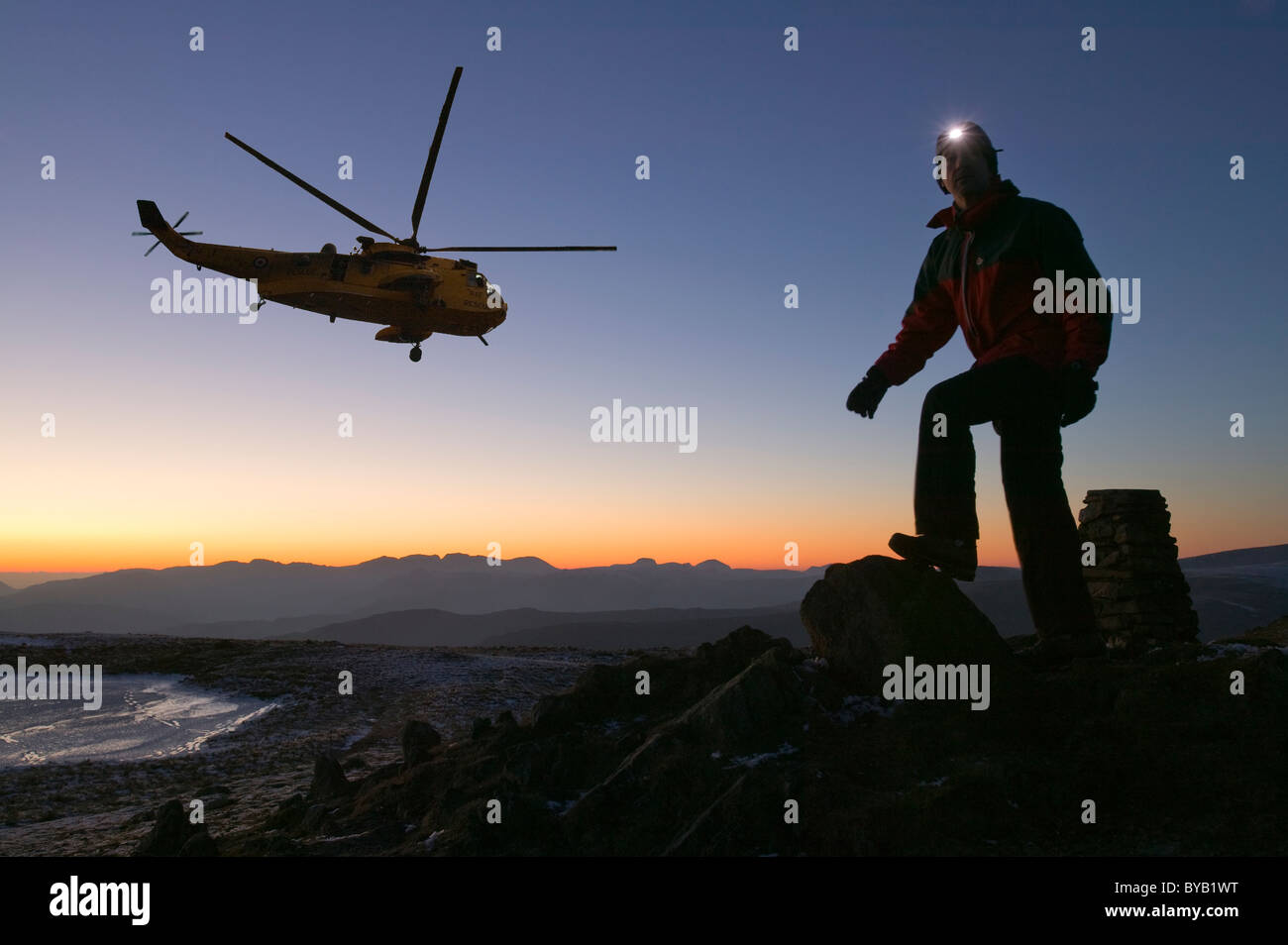 A walker on Red Screes in the Lake District UK at twilight, with a Sea ...