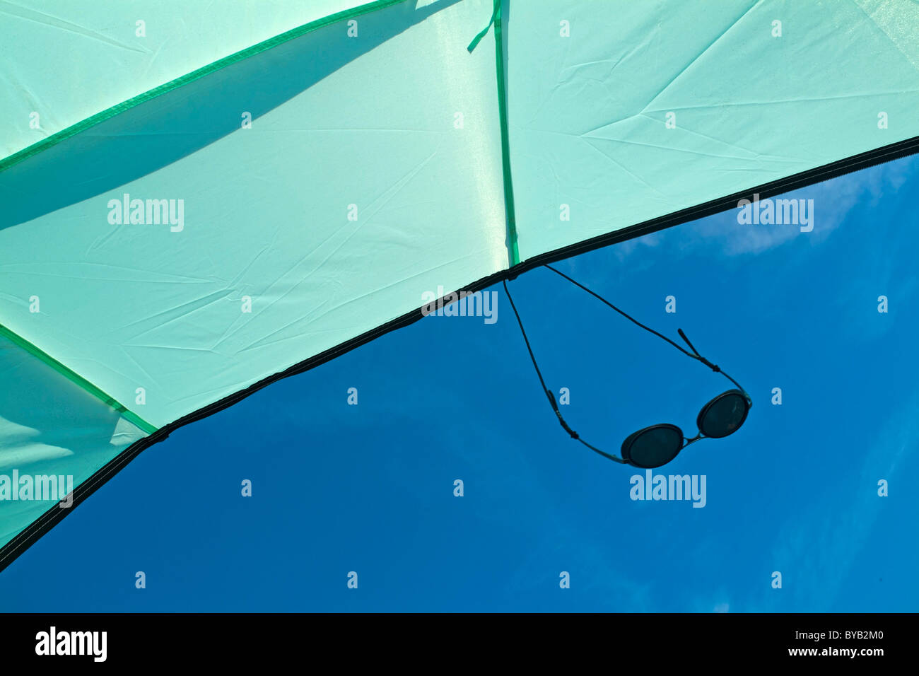 Sunglasses suspended from a sunshade against a blue sky Stock Photo - Alamy