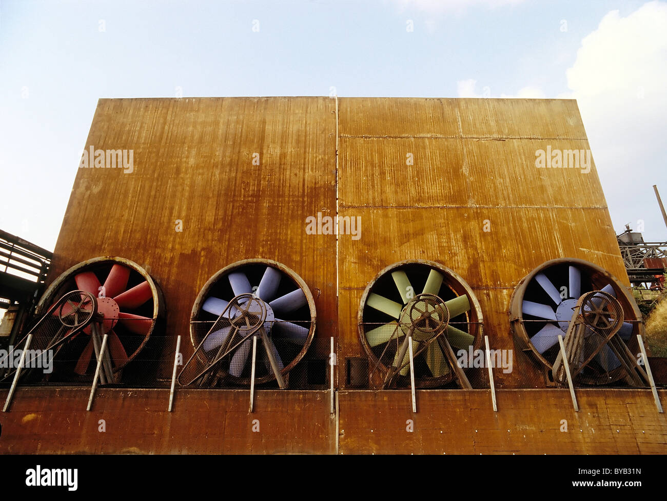 Industrial building with four brightly painted ventilation propellers ...
