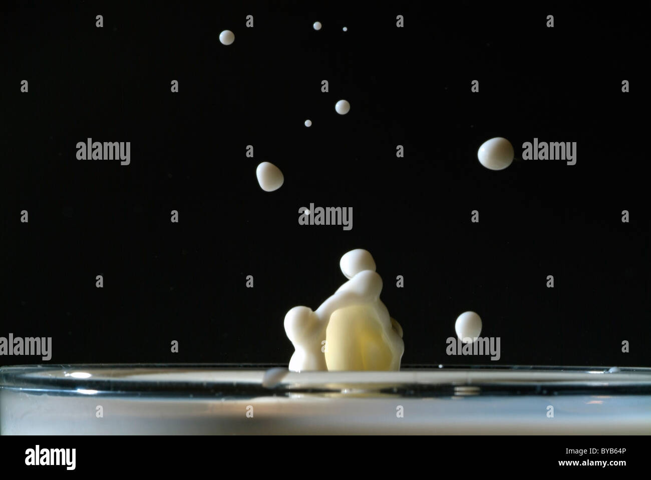 Drop of milk splashing in a glass Stock Photo - Alamy