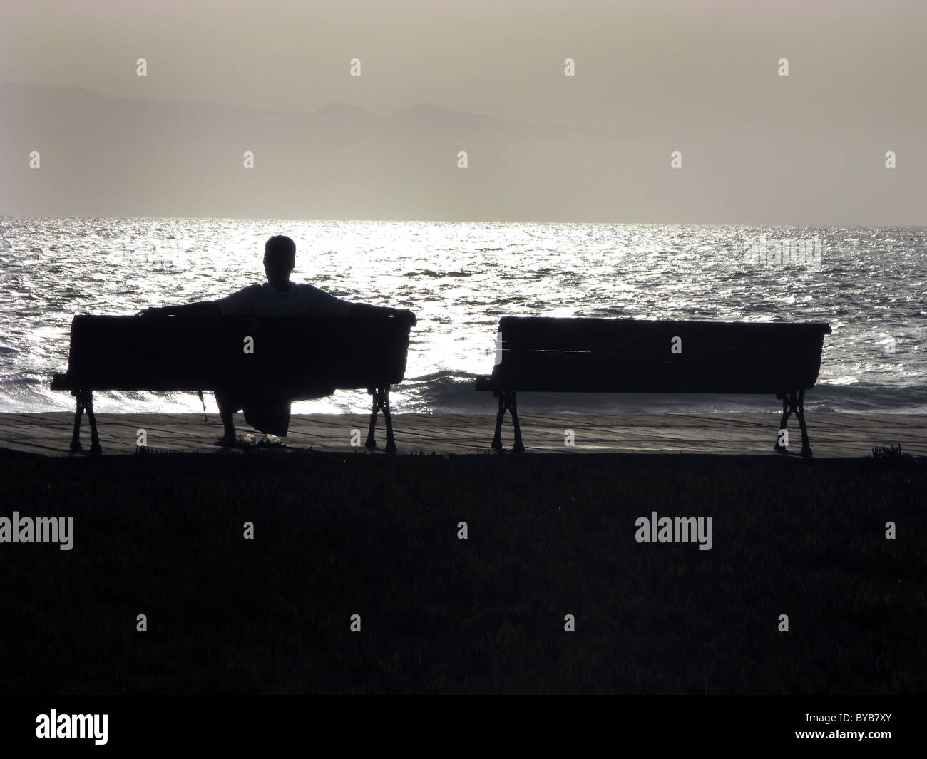 Person sat on bench boardwalk at sunset Stock Photo - Alamy