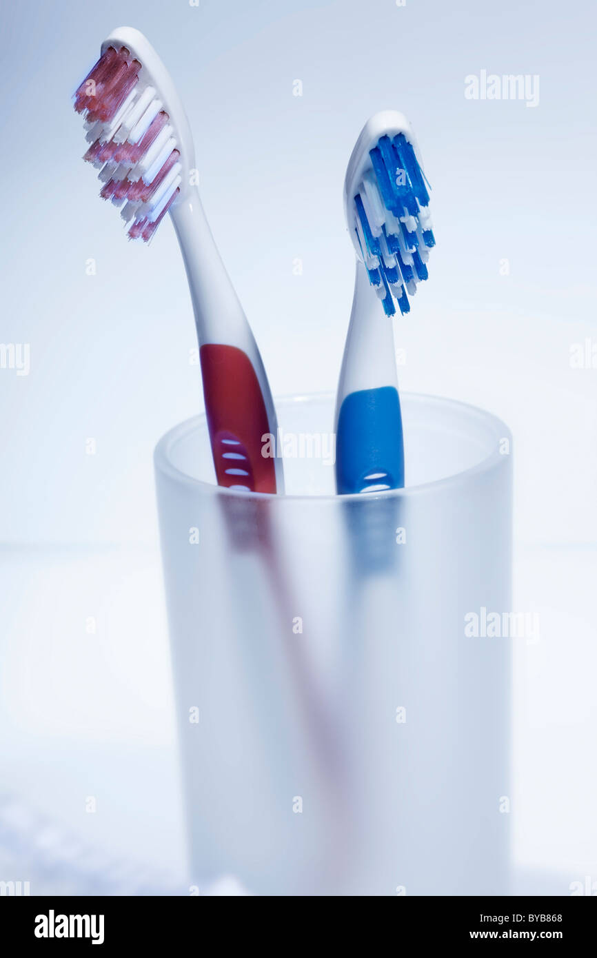 Water glass with a red and white and a blue and white toothbrush Stock ...