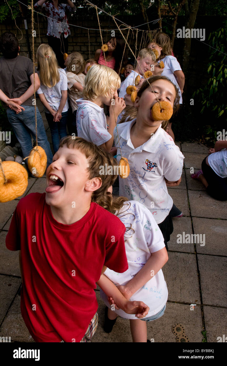 Children eating doughnuts off a string Stock Photo - Alamy