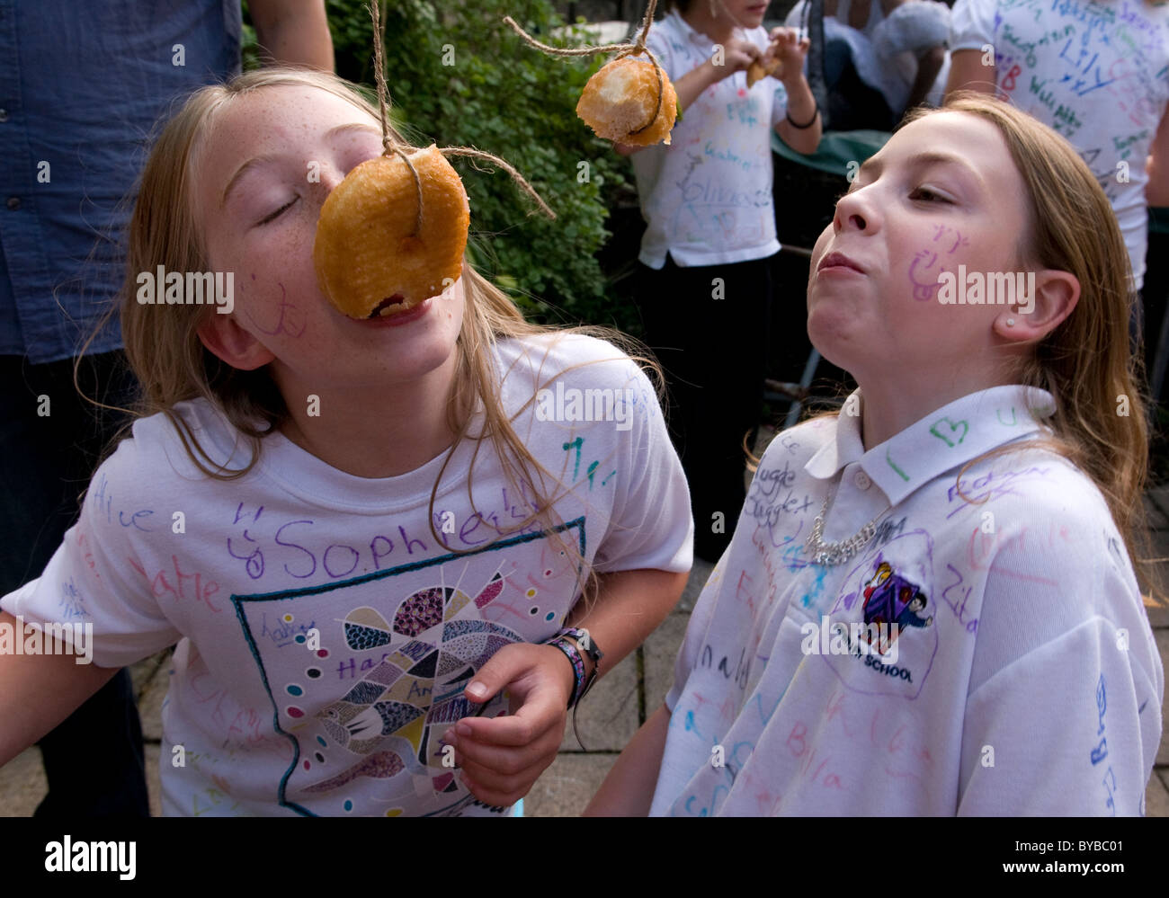 Children eating doughnuts off a string Stock Photo - Alamy
