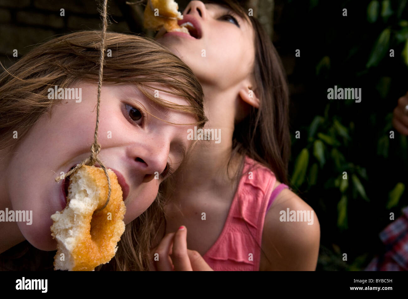 Children eating doughnuts off a string Stock Photo - Alamy