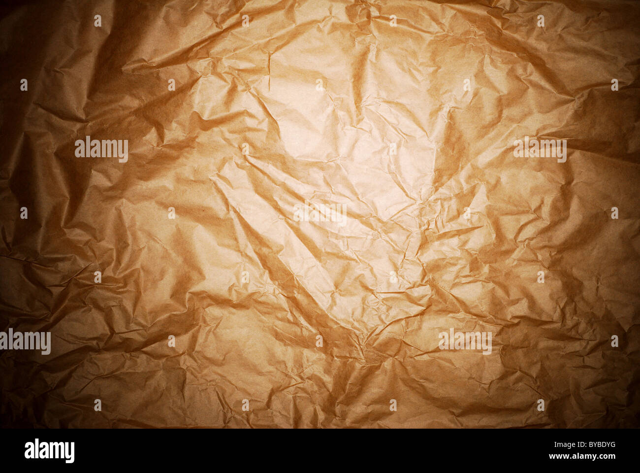 Brown crisped wrapping paped background with spotlight in the center ...