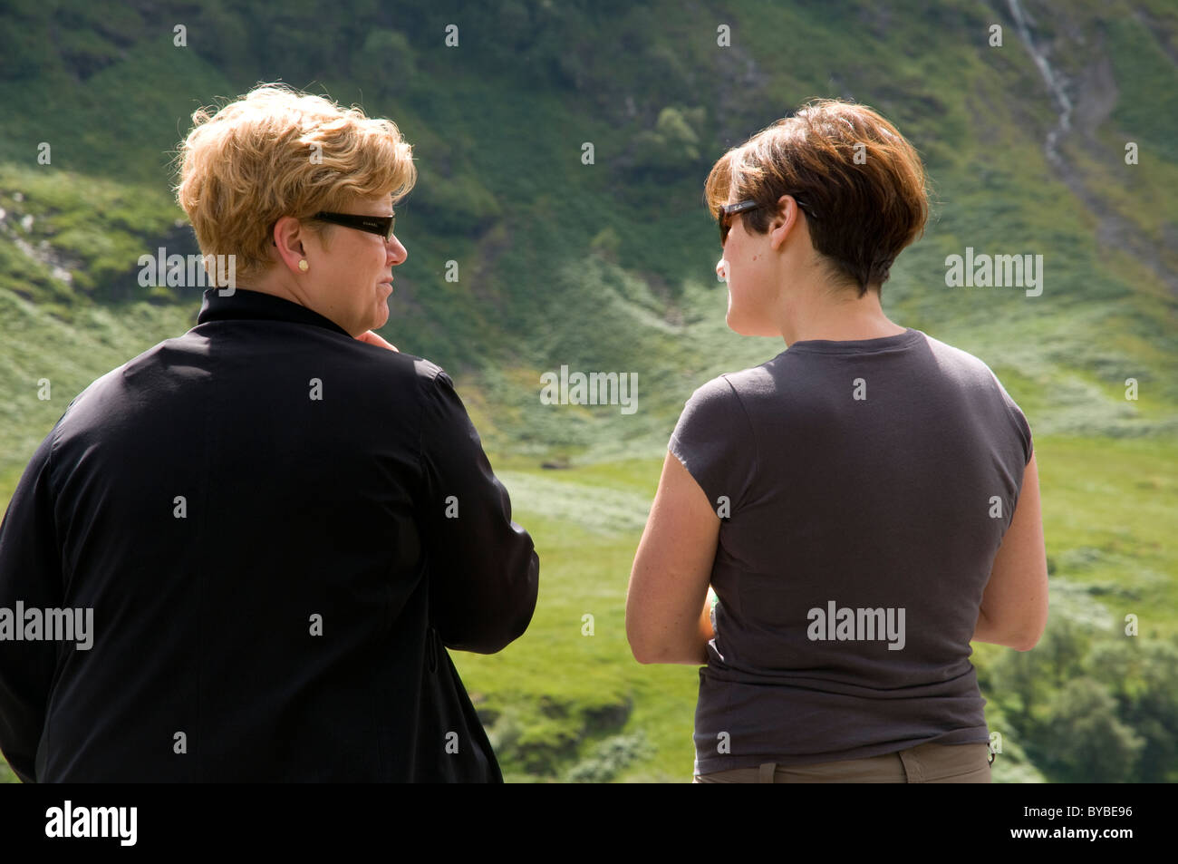 Two women standing and looking across a valley Stock Photo - Alamy