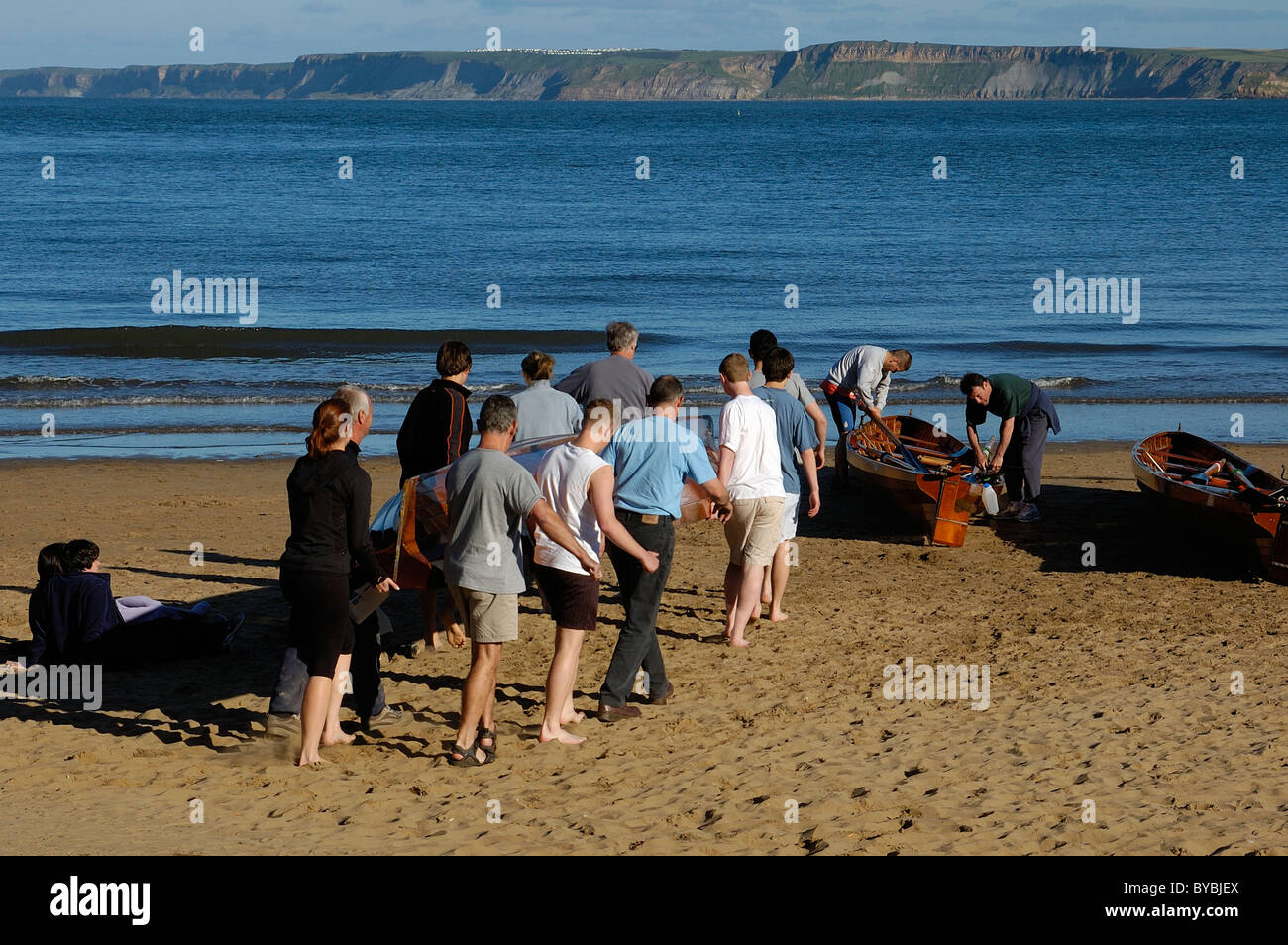 A team of rowers prepare to enter the water Scarborough england uk ...
