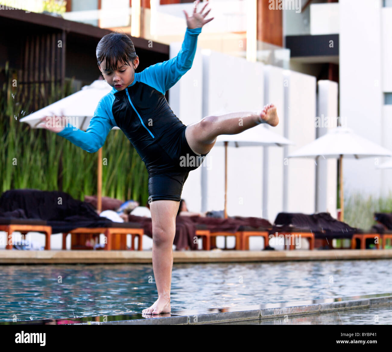 5yr old, handsome boy, does one leg balancing act at the side of a ...