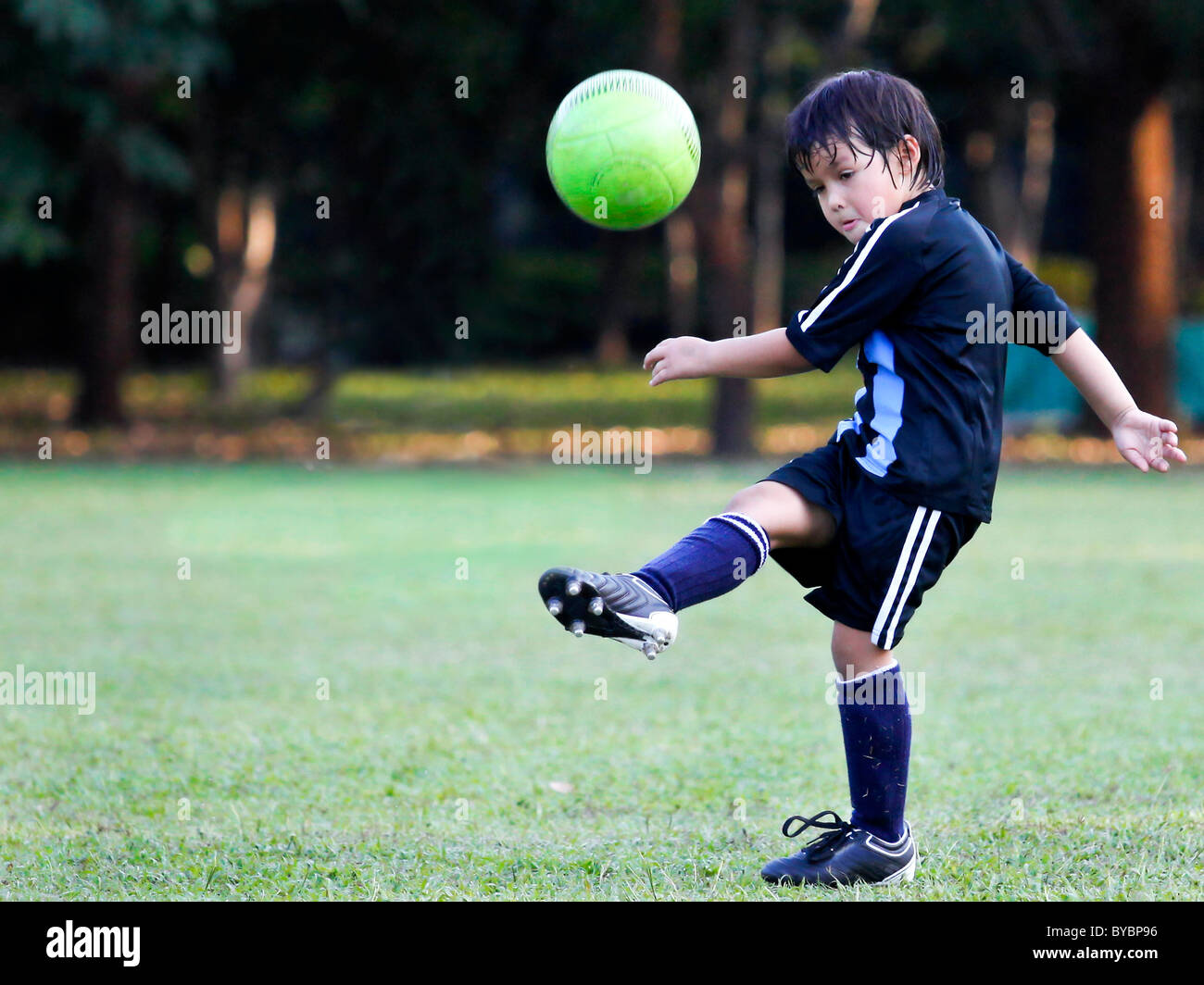 5yr old shows good football skills and a determined look Stock Photo ...