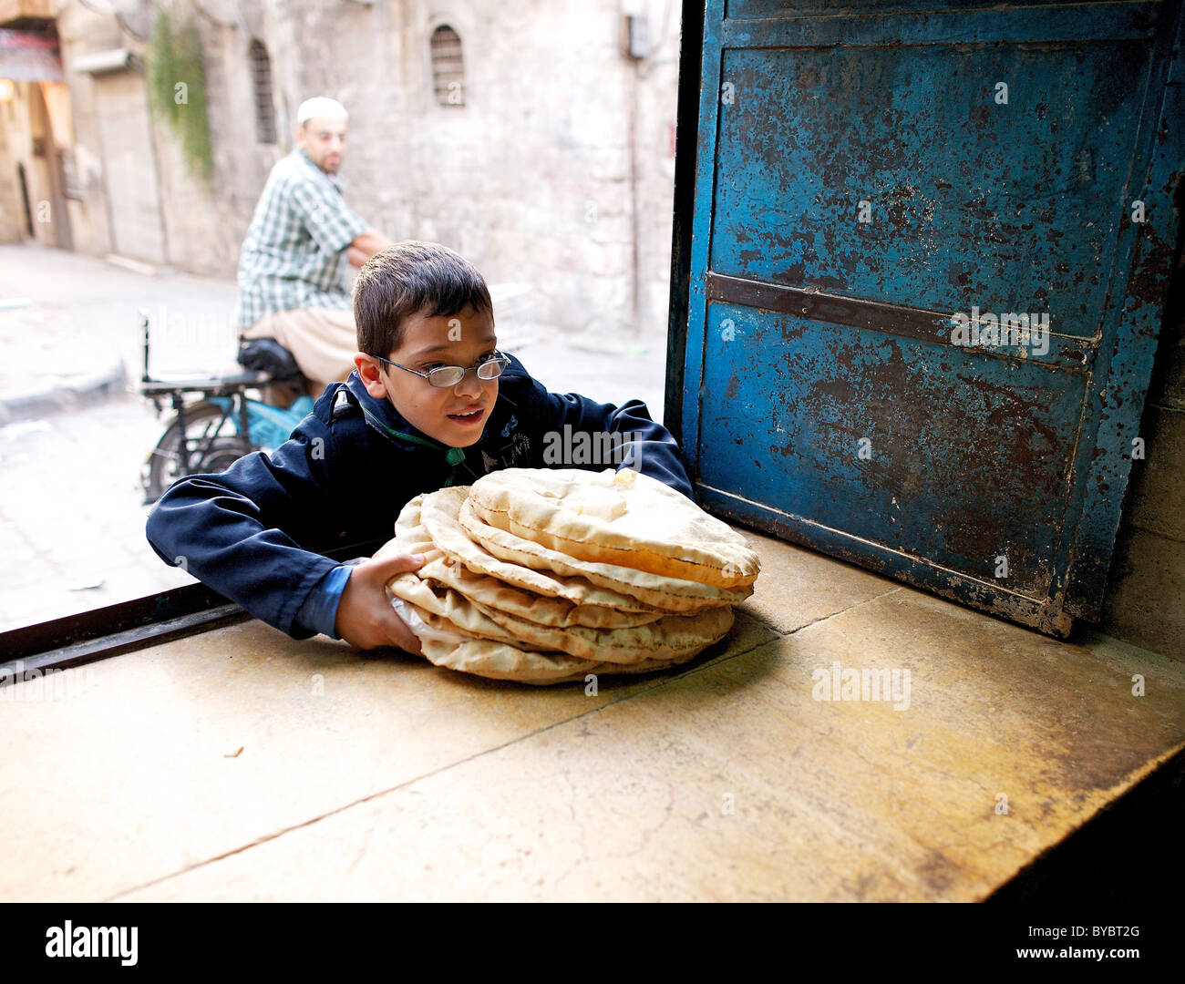 Syrian schoolboy collecting fresh bread from local bakery early in the ...