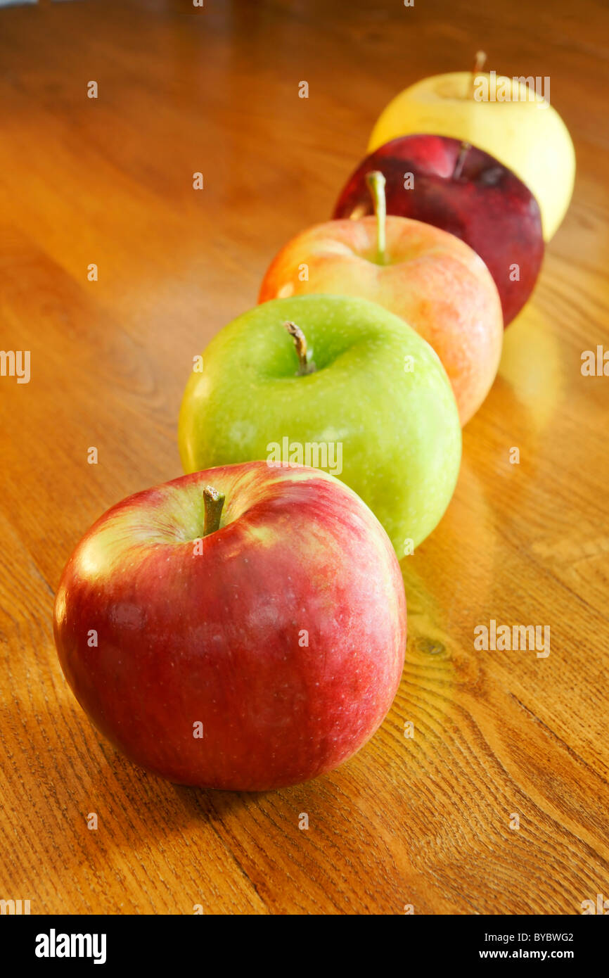 Apples of all kinds in a row on a kitchen wooden table: cortland ...