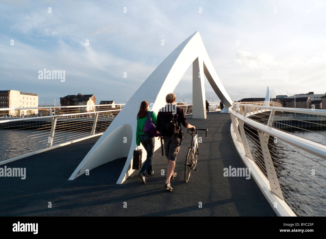 Pedestrian and cyclist walking across the Broomielaw Tradeston ...