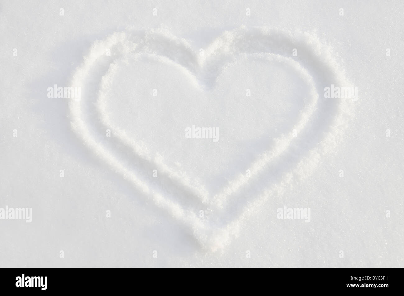 Heart drawn on snow Stock Photo - Alamy
