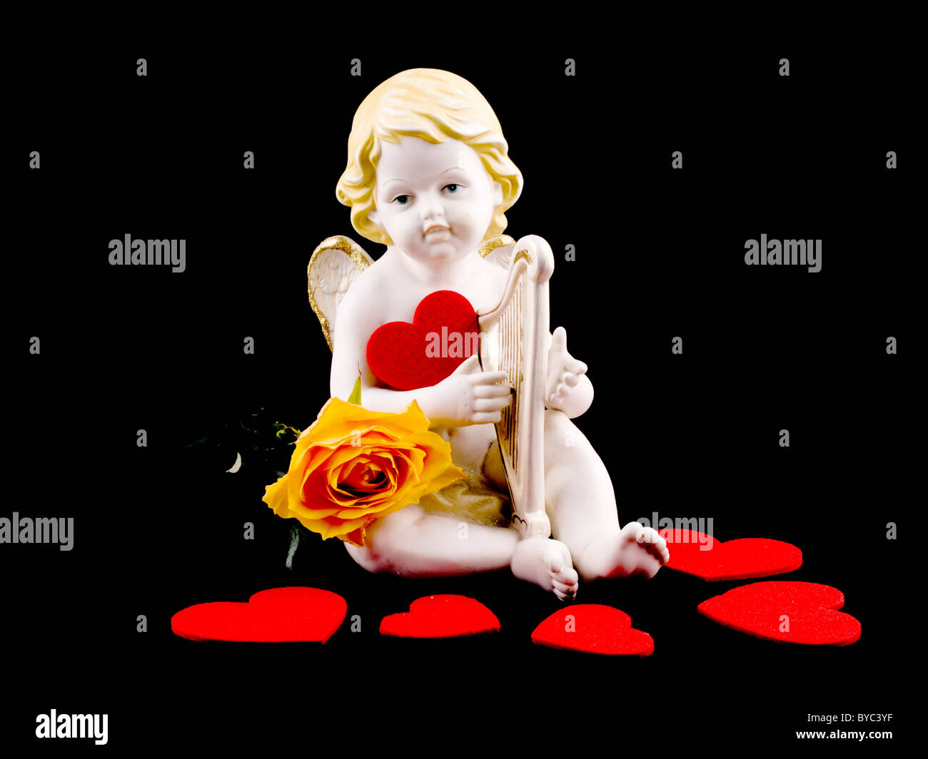 Ceramic cupid figure with felt red heart and tea rose on black ...