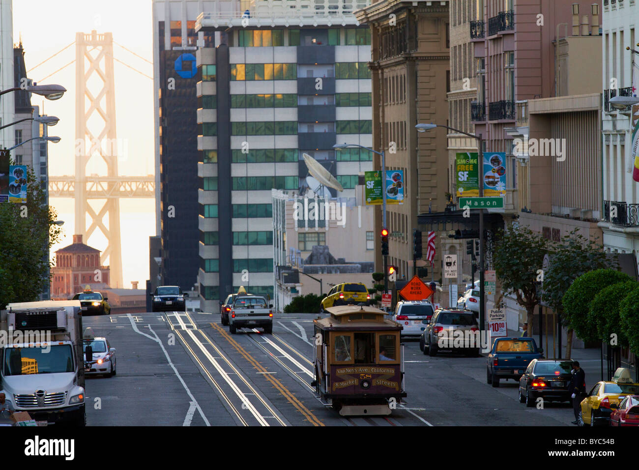 Cable Car makes its way through morning traffic, Bay Bridge in ...