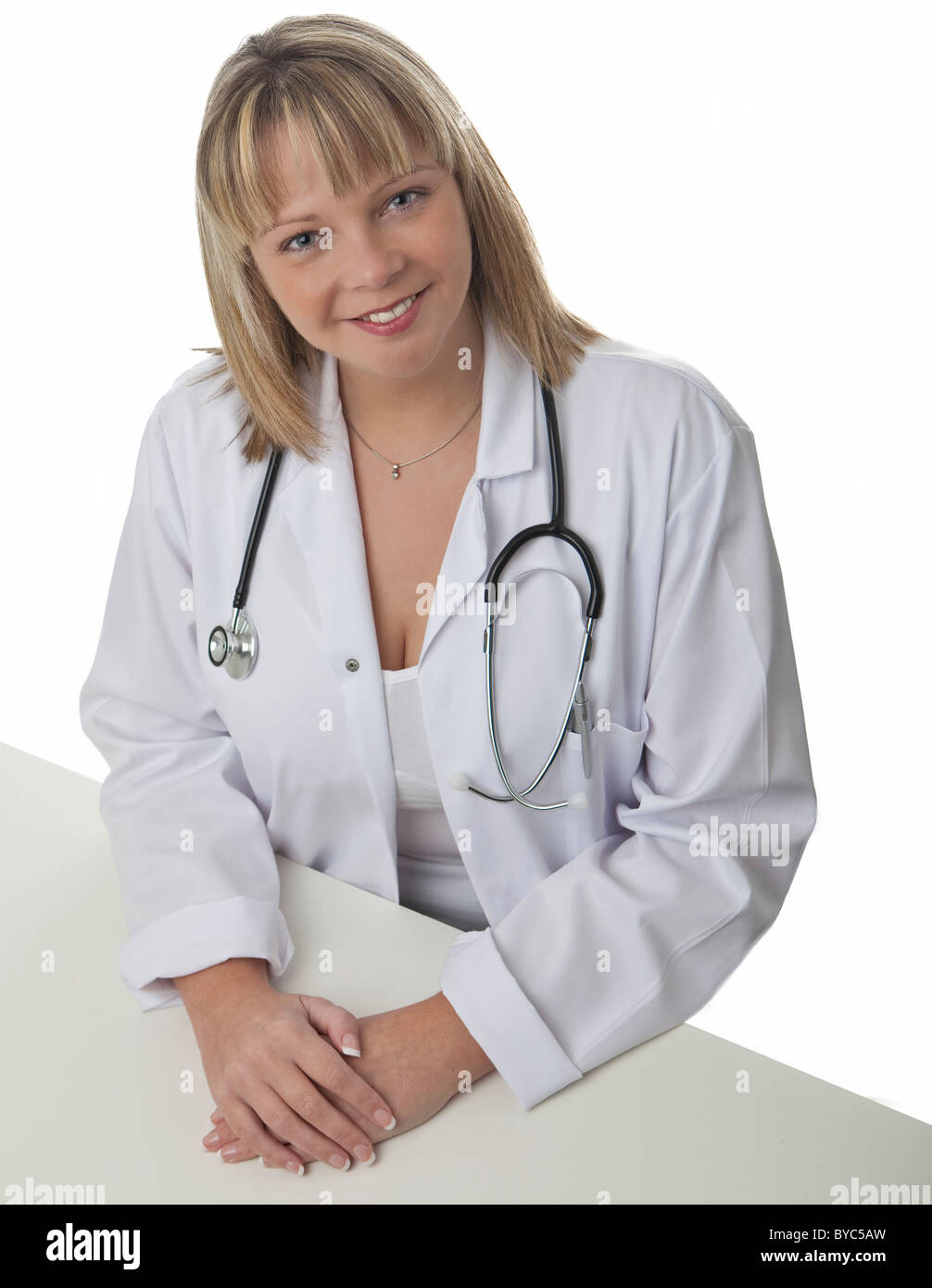 attractive young female doctor sitting at her desk, smiling at the ...