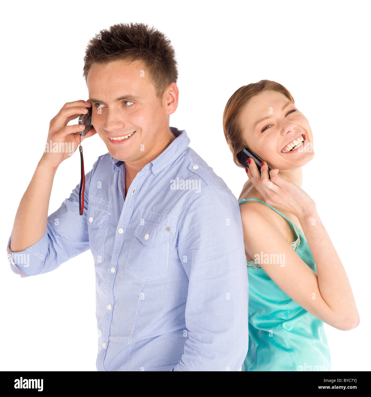 Young happy smiling couple standing back to back, talking on the phone ...