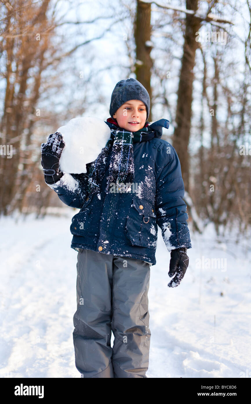 Happy cute boy playing in the snow near a forest Stock Photo - Alamy