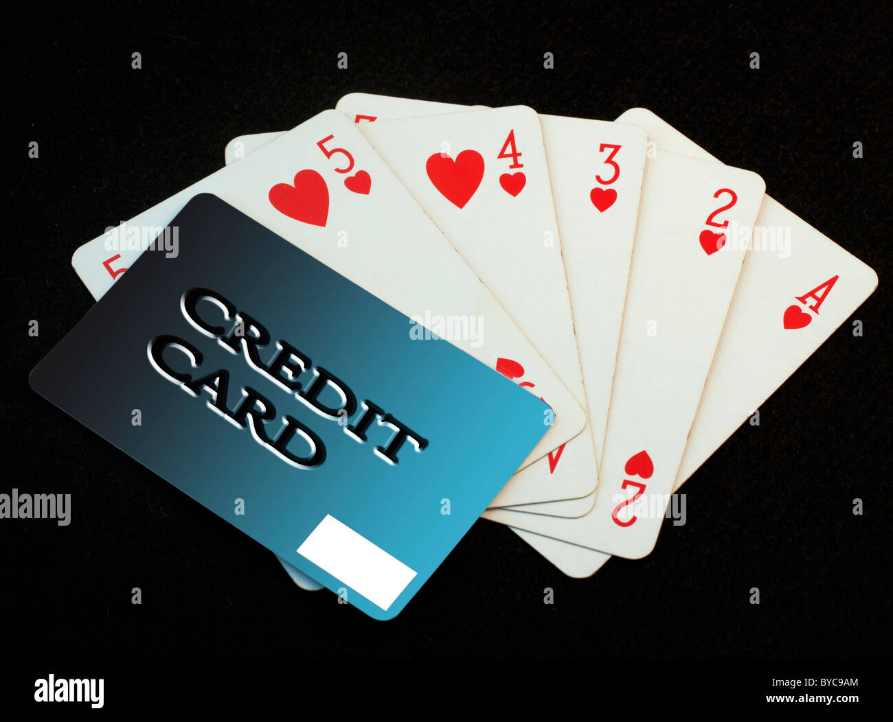 Four playing cards and a credit card over black Stock Photo - Alamy