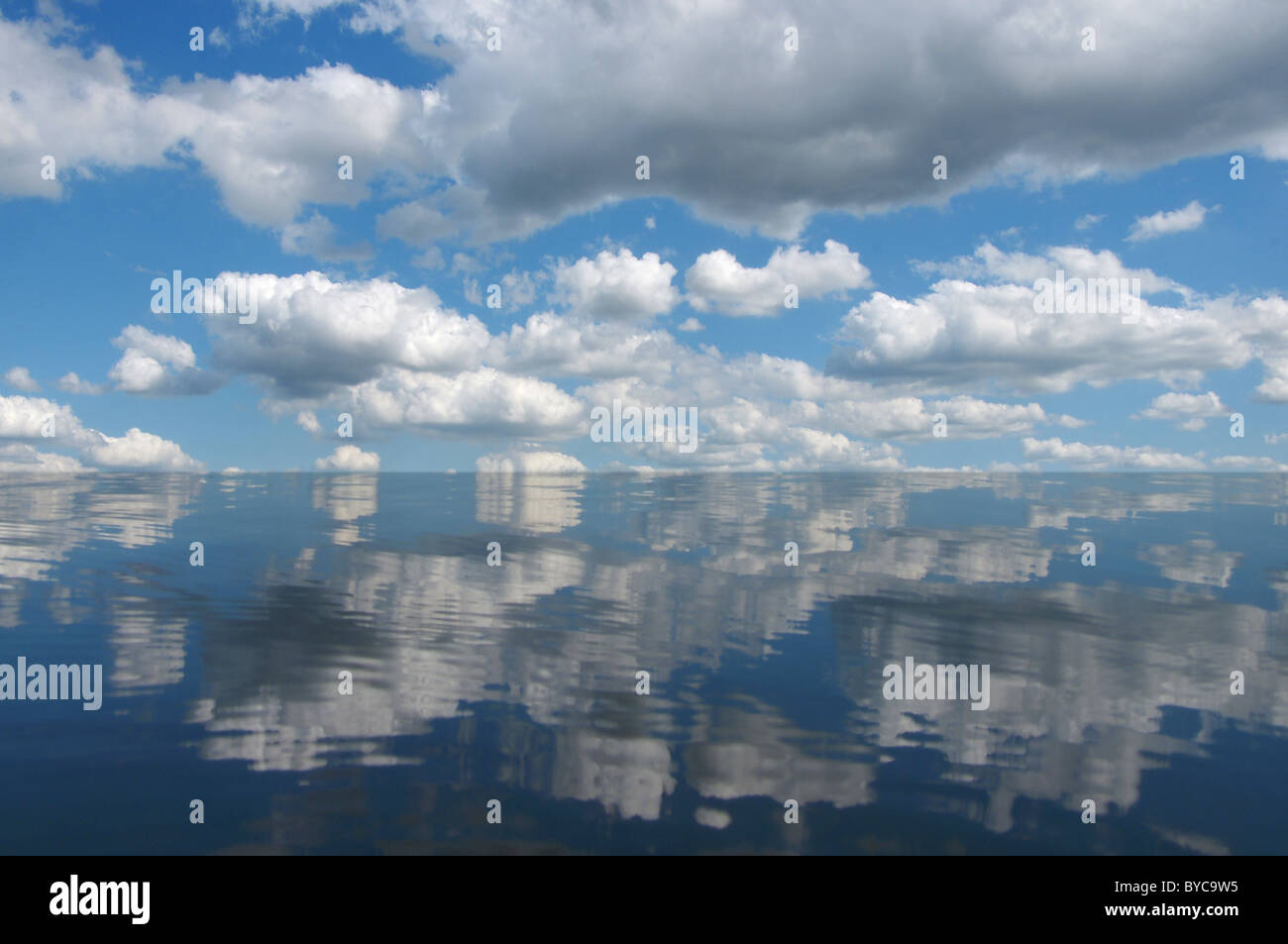 Blue sky with white sky reflection in water Stock Photo - Alamy