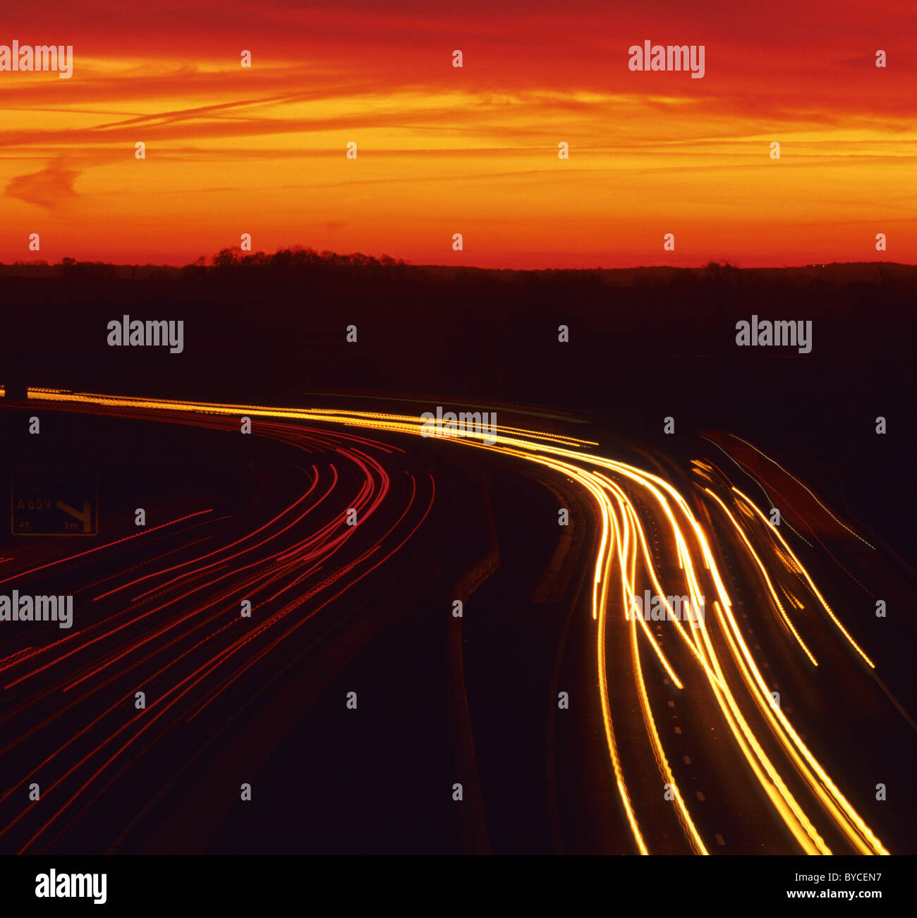 headlight trails of traffic travelling on the M1 motorway at sunset ...