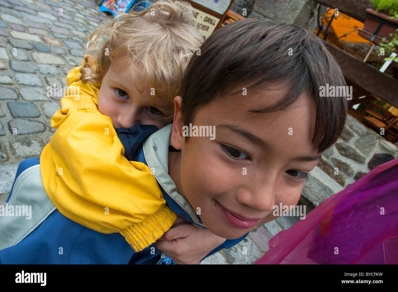 Young boy carrying his cousin on his back, Brittany, France Stock Photo ...