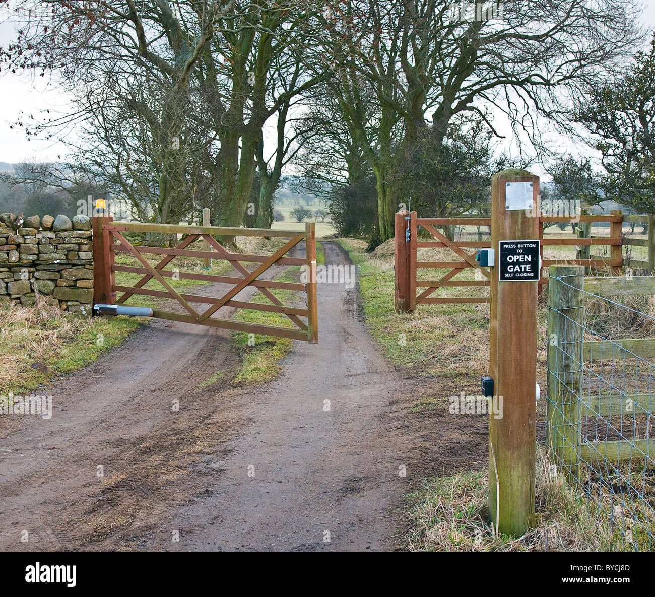 country lane with a self closing electric gate Stock Photo - Alamy