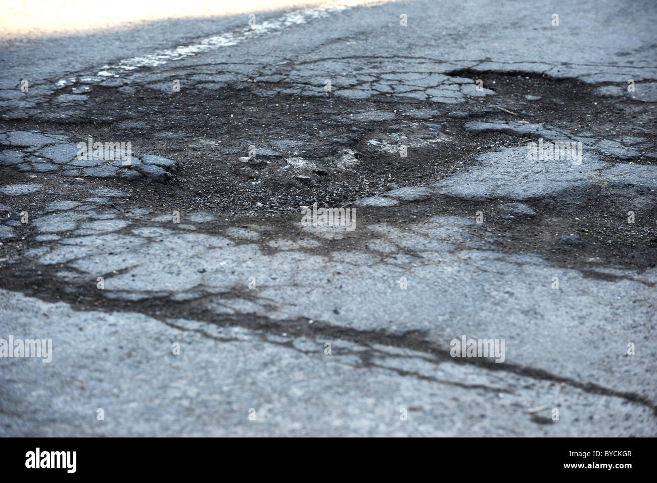 Deep potholes in a busy road caused by the recent snow and freezing ...