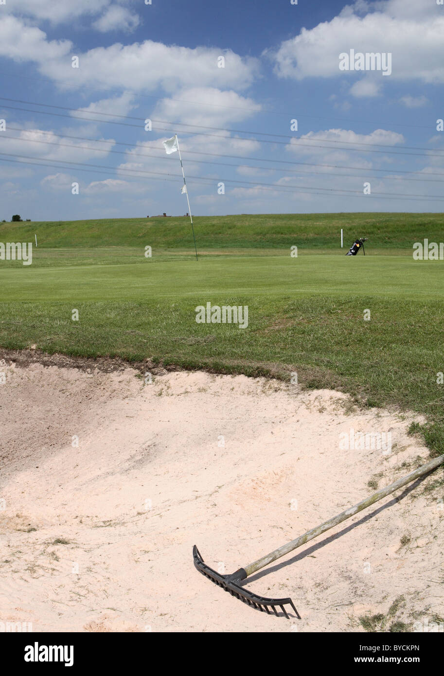 Bunker and rake by the green on a golf course Stock Photo - Alamy