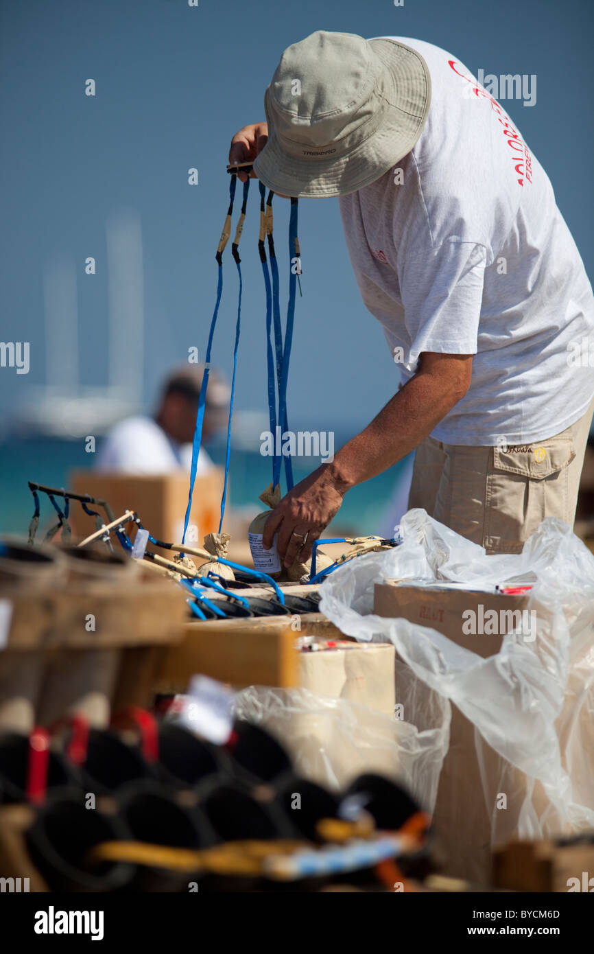 Worker installing firework bombs on a floating raft on the beach. 14th ...