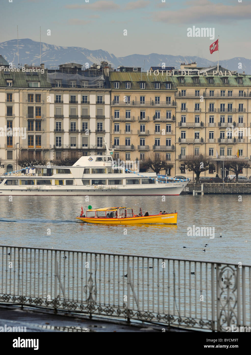 A yellow ferry in the city of Geneva waterfront on Lake Geneva ...