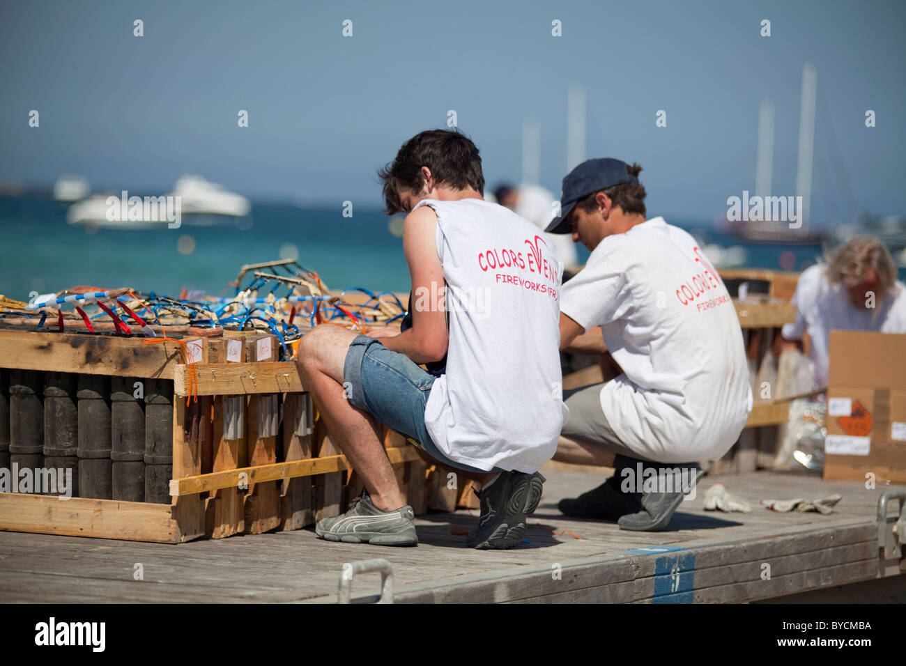 Young Men installing firework bombs on a floating raft laying on the ...