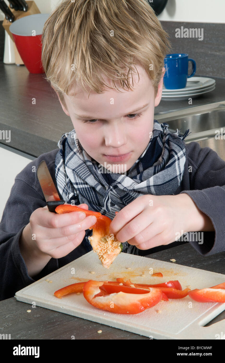 Boy cutting a red pepper, getting ready to cook Stock Photo - Alamy