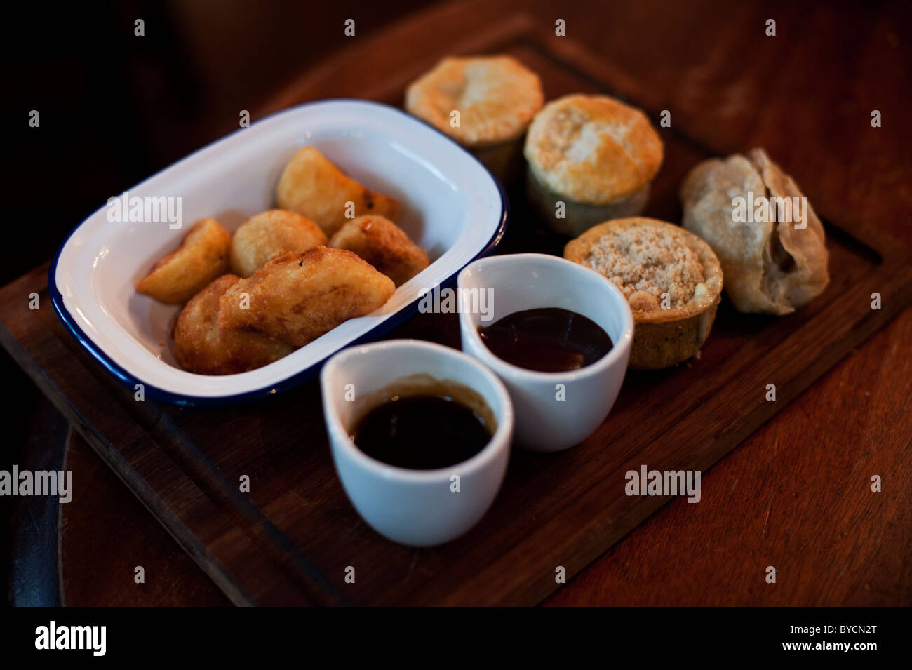 A platter of roasted potatoes and a tasting sample of pies and gravy at ...