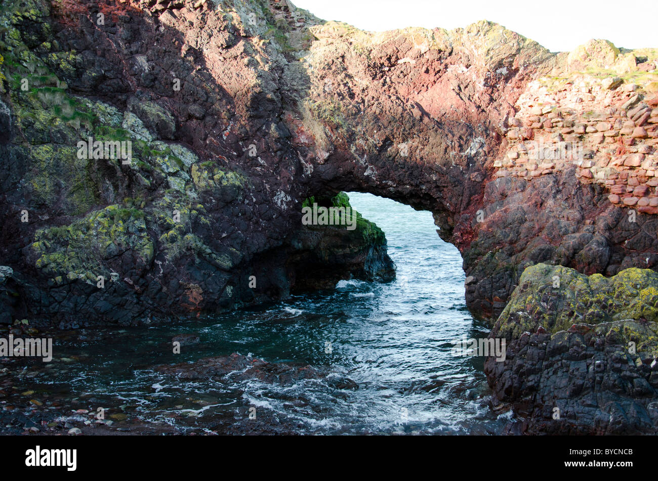Old arch over the sea, part of the castle remains in Dunbar, East ...