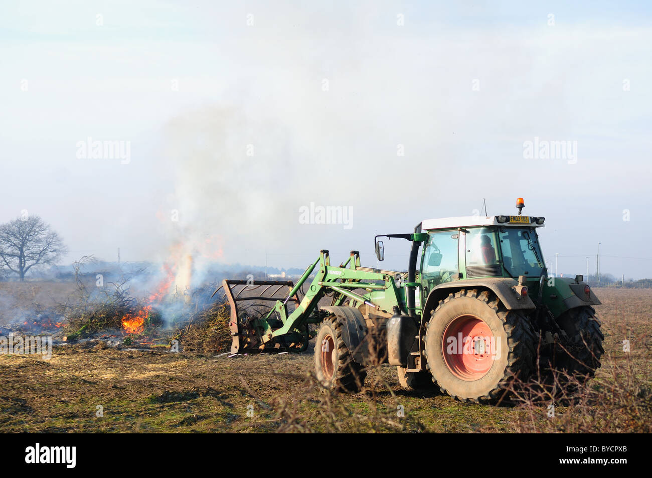 Farming Tractor Clearing Old Hedge Cuttings Stock Photo - Alamy
