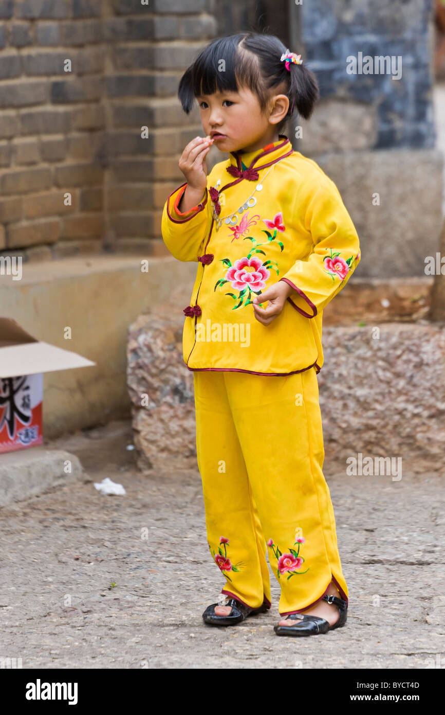 Young Chinese girl in yellow embroidered suit in Lijiang old town ...