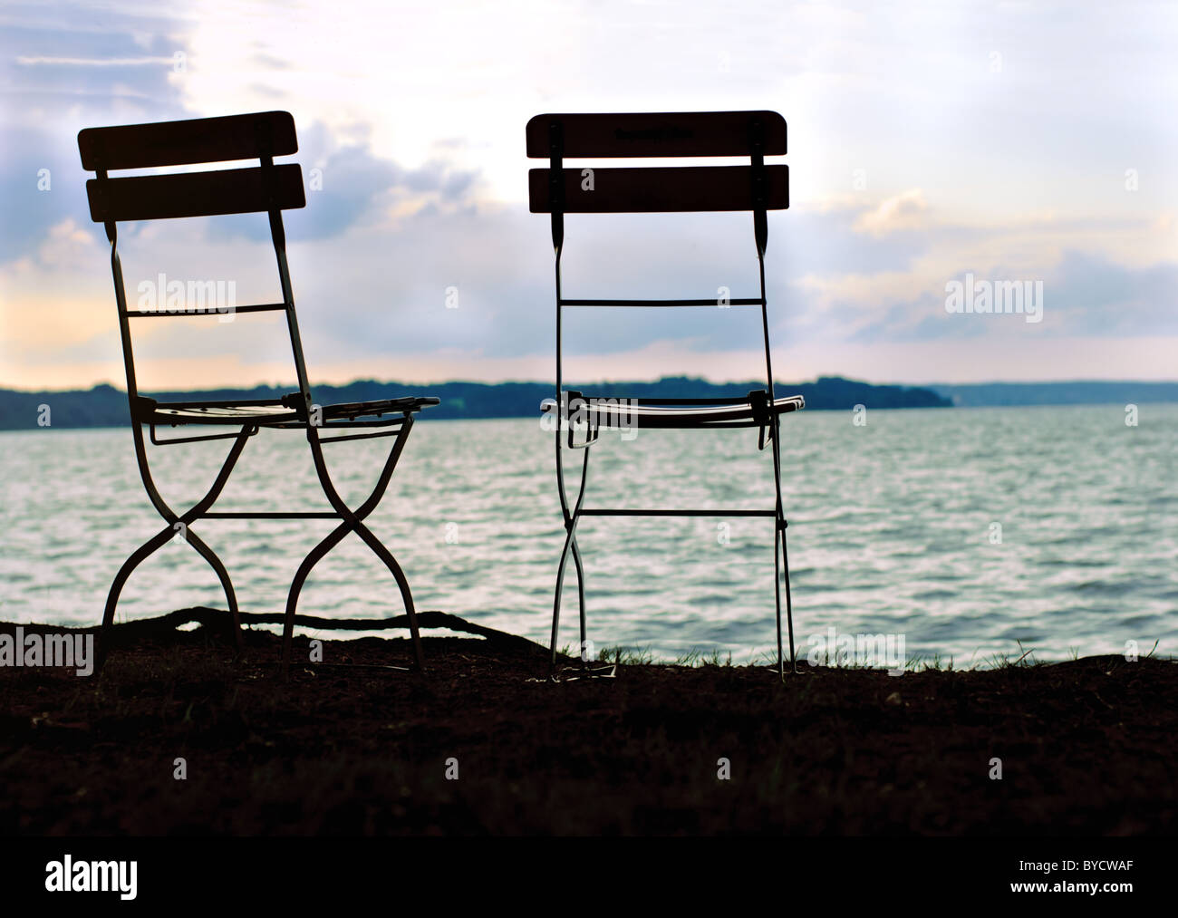 Two chairs near tha lake. silhouette Stock Photo - Alamy