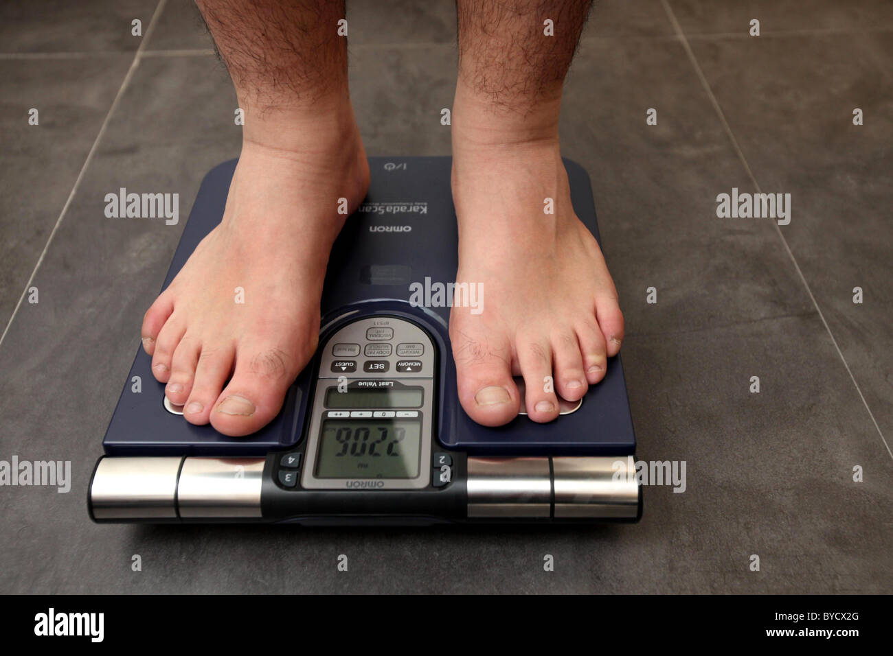 Man on a set of weight scales Stock Photo - Alamy