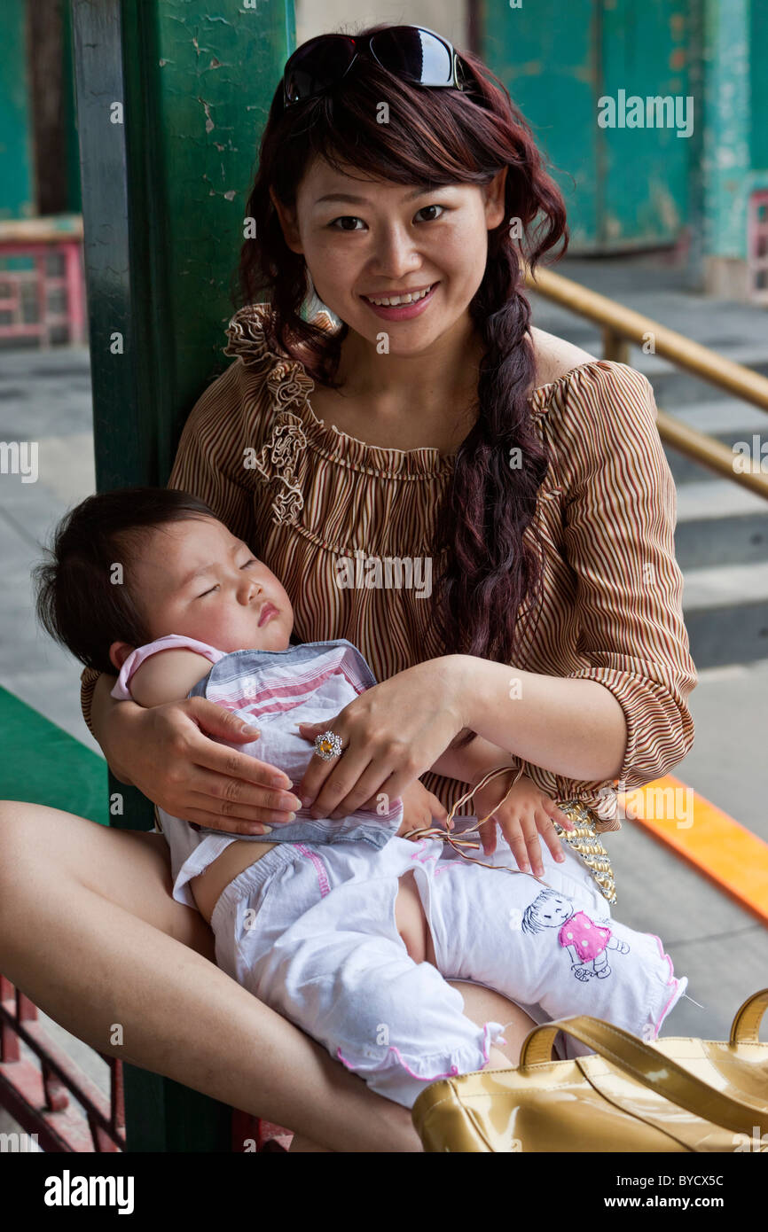 Beautiful smiling young Chinese mother and her baby daughter in the ...