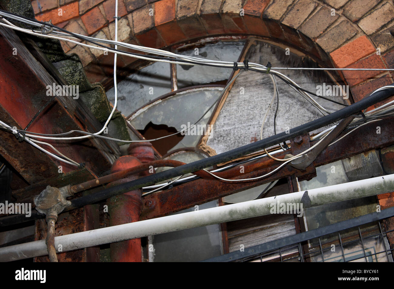 A wiring disaster on the outside of a building next to the downpipe and ...