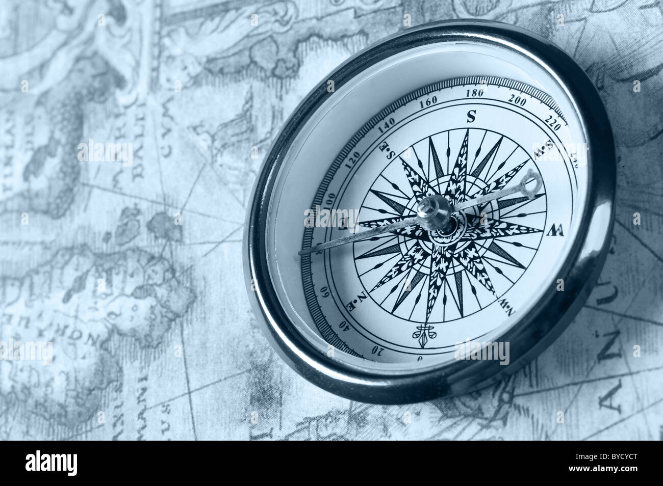 Old compass on ancient map. Blue toned image Stock Photo - Alamy