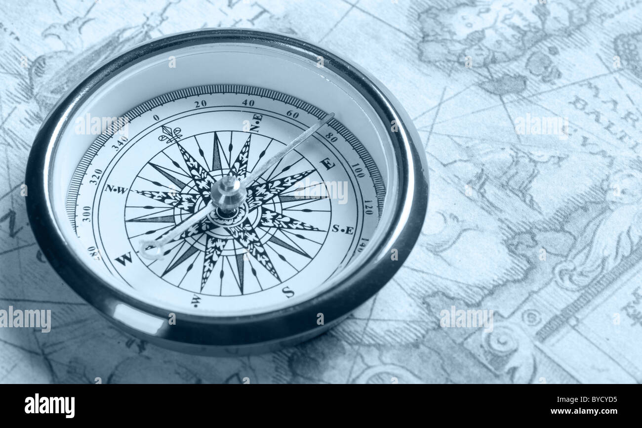 Old compass on ancient map. Blue toned image Stock Photo - Alamy