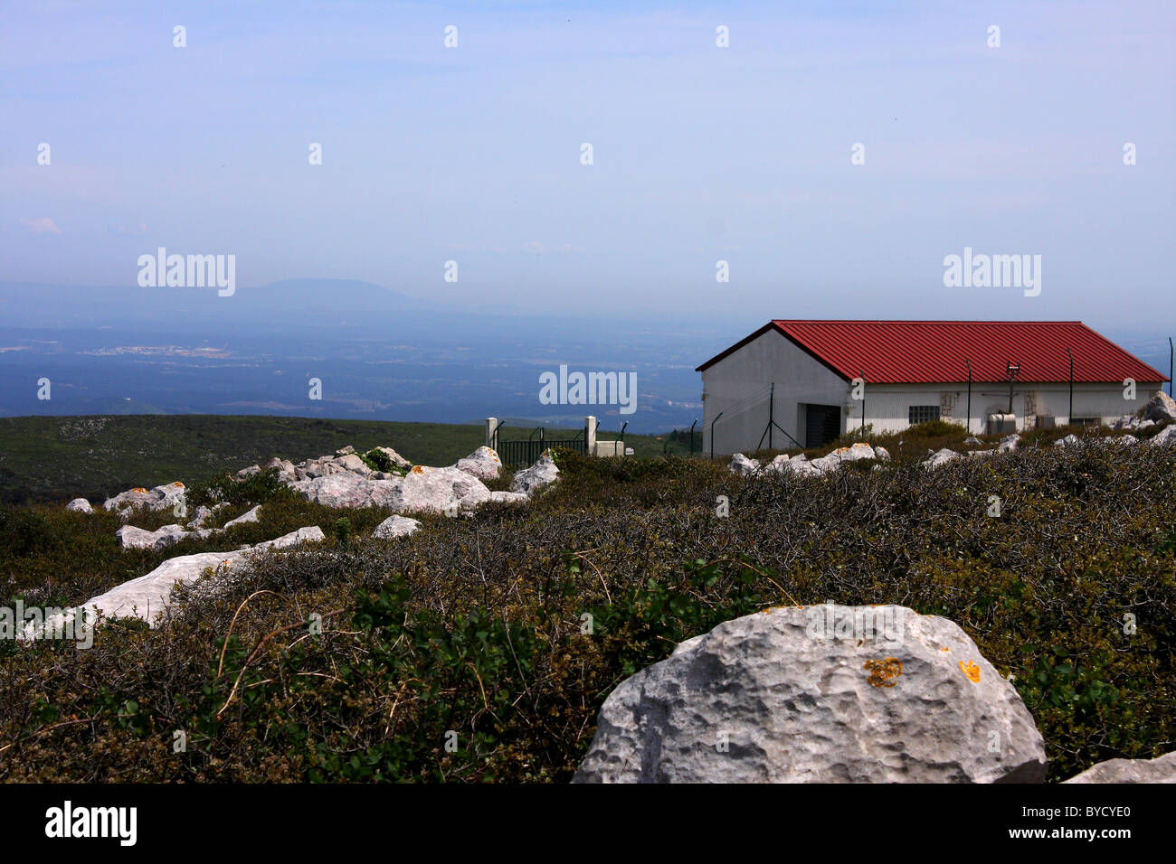 A house on a hill looking over Portugal beside a bunch of white rocks ...