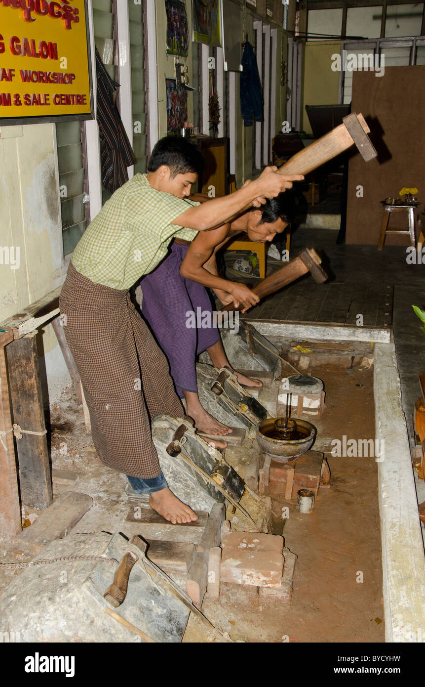 Myanmar (aka Burma), Mandalay. Gold leaf workshop, men beating gold ...
