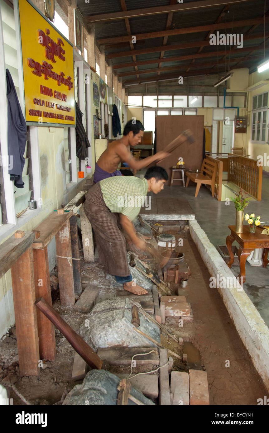 Myanmar (aka Burma), Mandalay. Gold leaf workshop, men beating gold ...