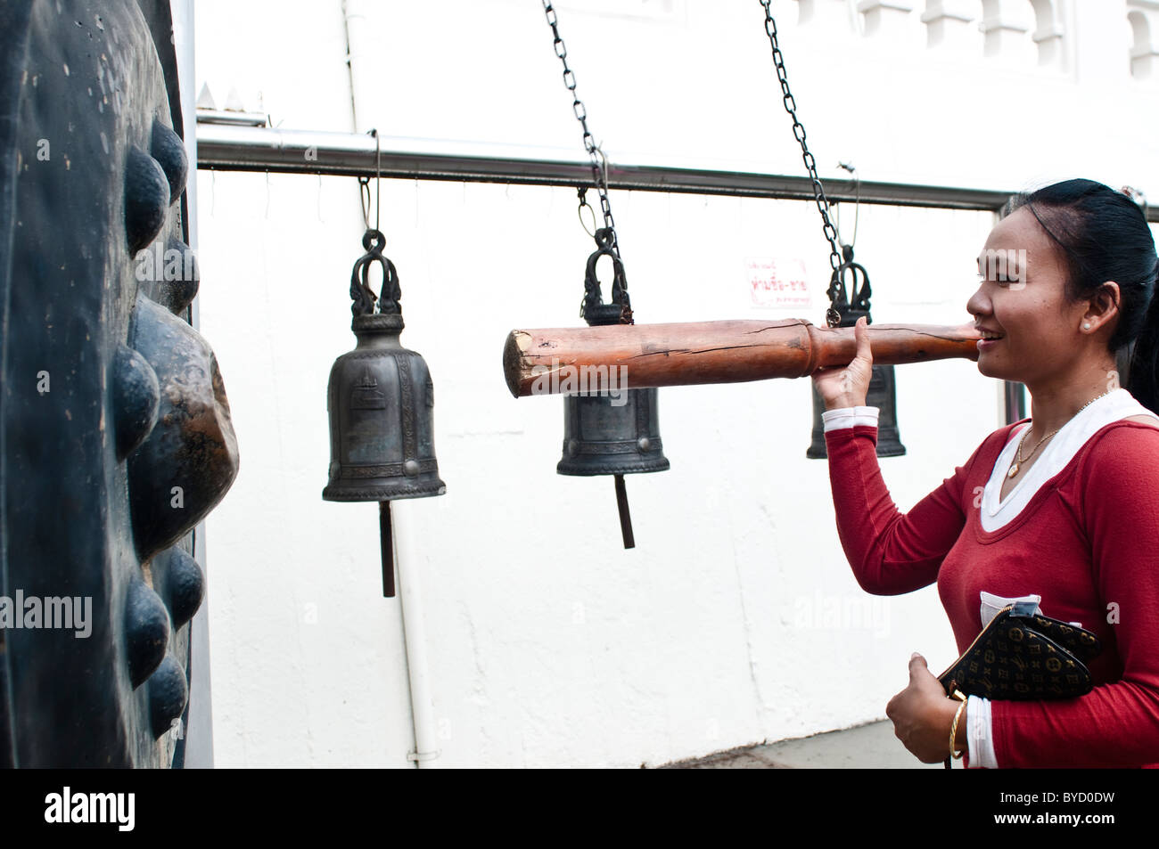 Woman hitting the gong, Golden Mount, Sakesa Temple, Bangkok, Thailand ...
